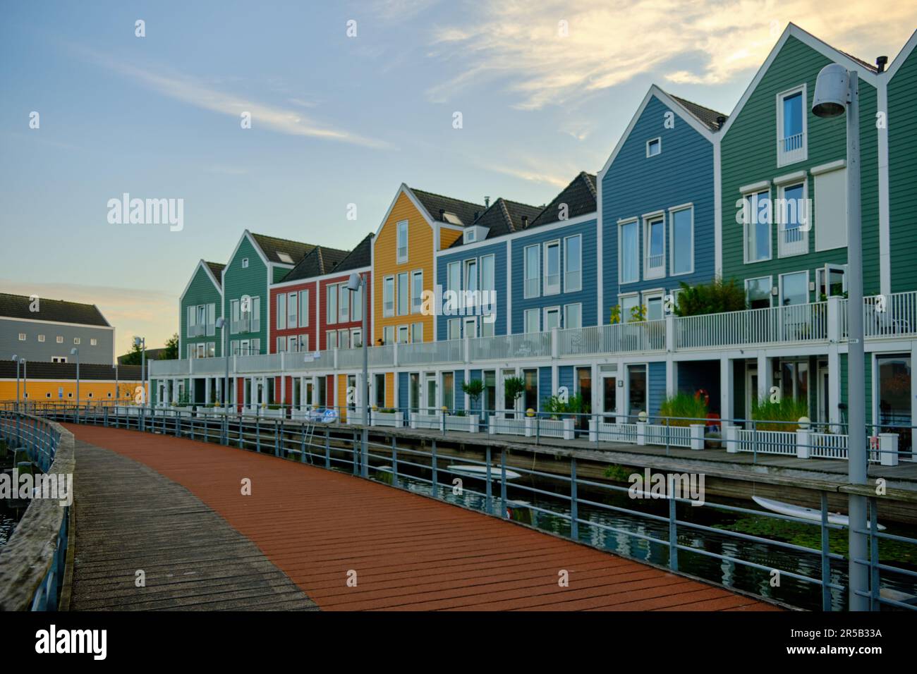 Row of colourful wooden newly built Dutch houses surrounded by water of ...