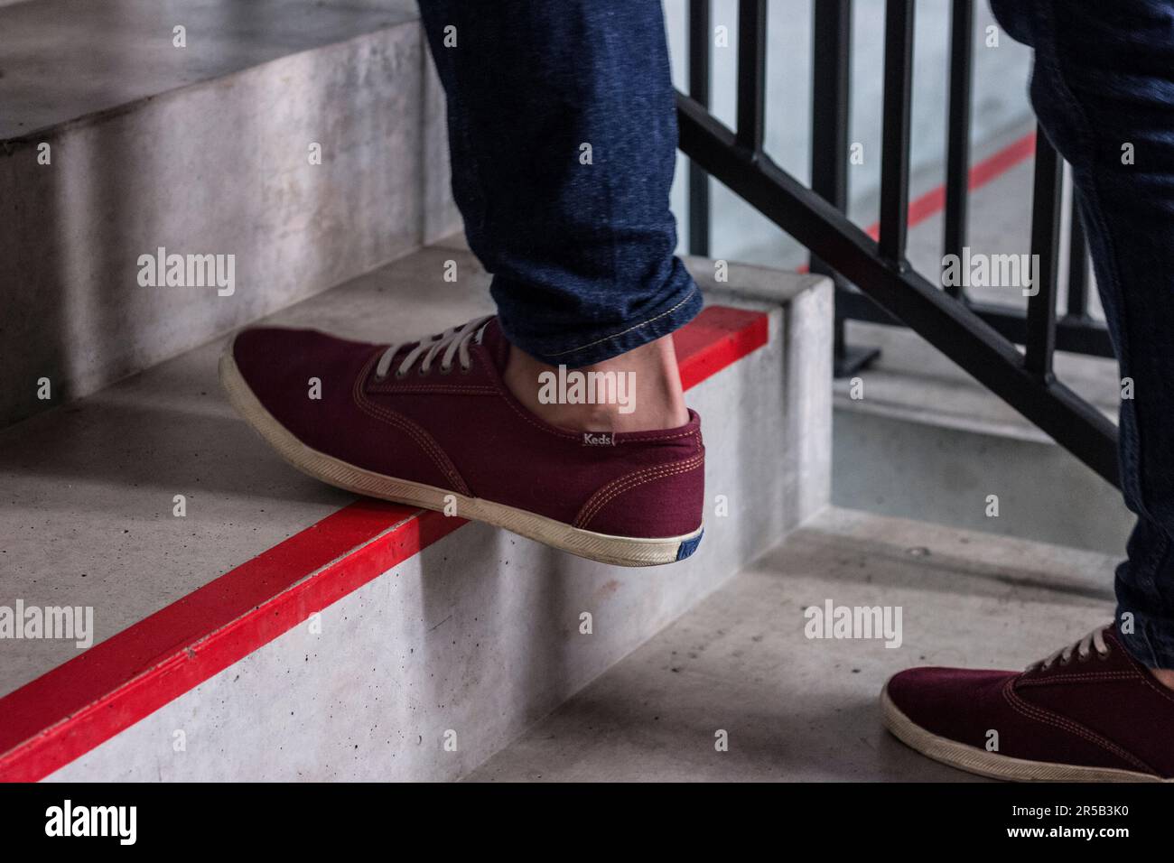 A close-up shot of a male feet wearing red keds on the stairs Stock ...