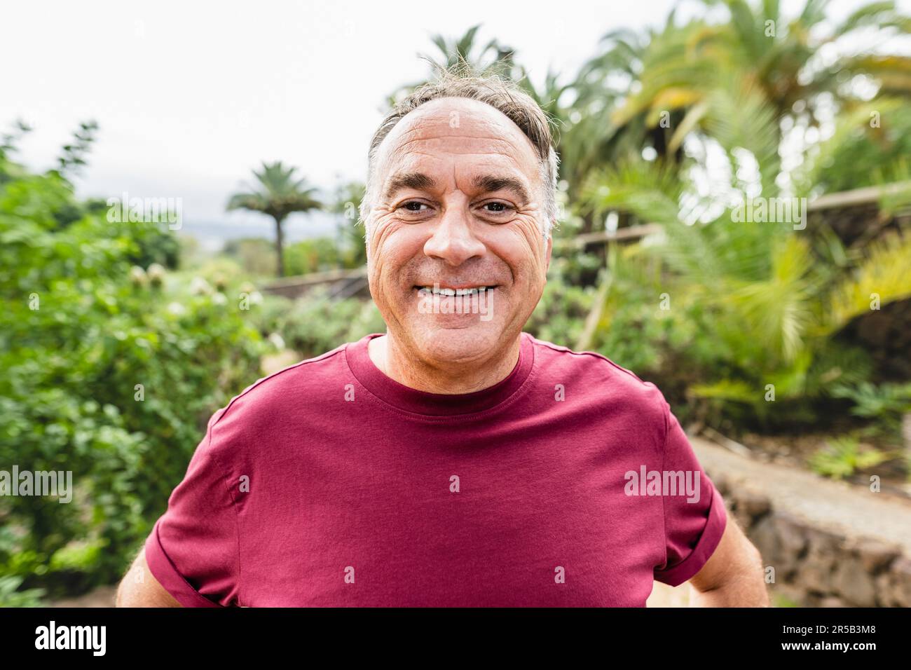 Happy senior man smiling into the camera while doing sports activity in ...