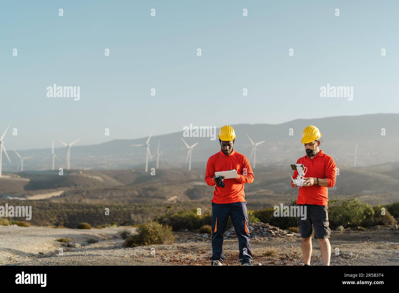 Drone engineers working on wind turbine farm - Alternative energy and ...