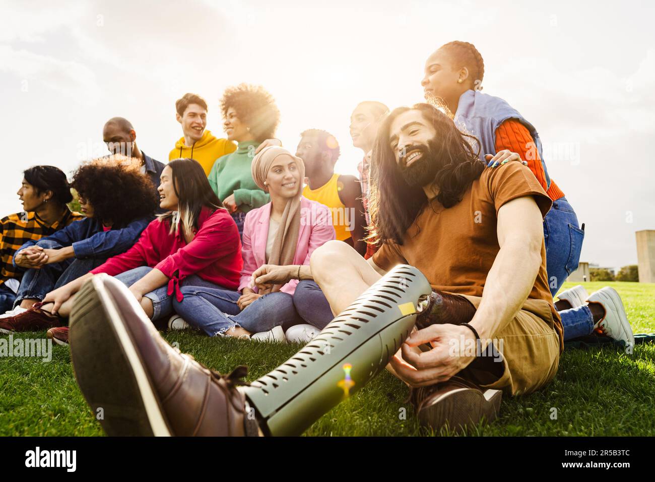 Multi ethnic group having fun in a public park - Amputee man hangs out ...