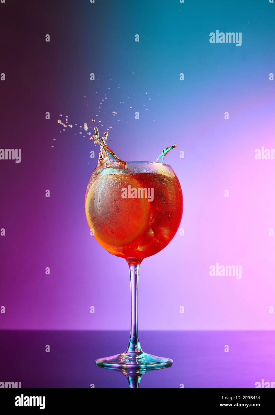 Classic italian aperol spritz cocktail in glass over gradient neon ...