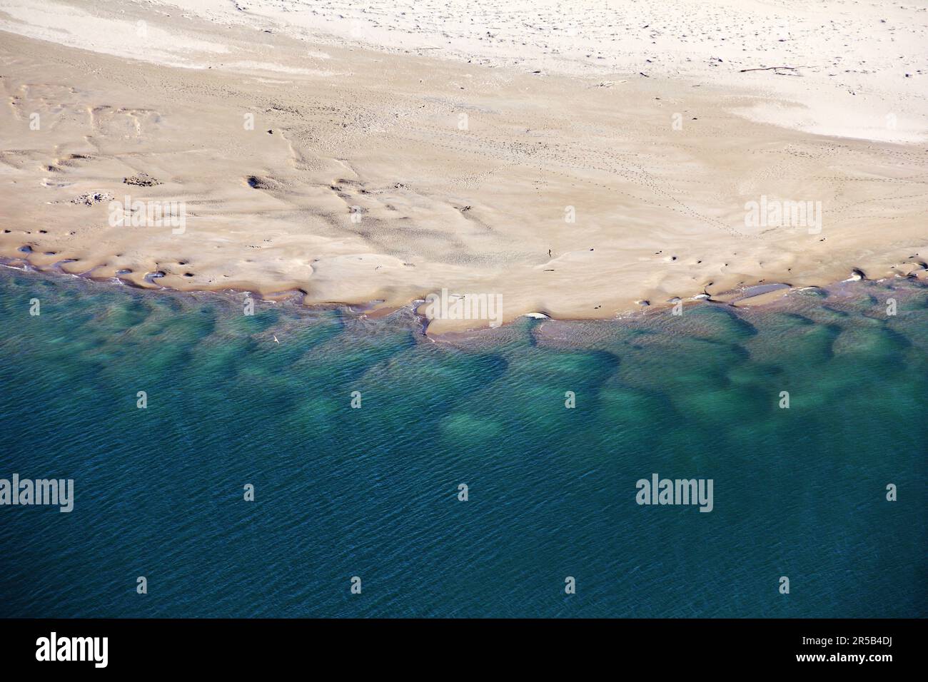An aerial view of the teal waters and sandy shoreline of a beach in New ...