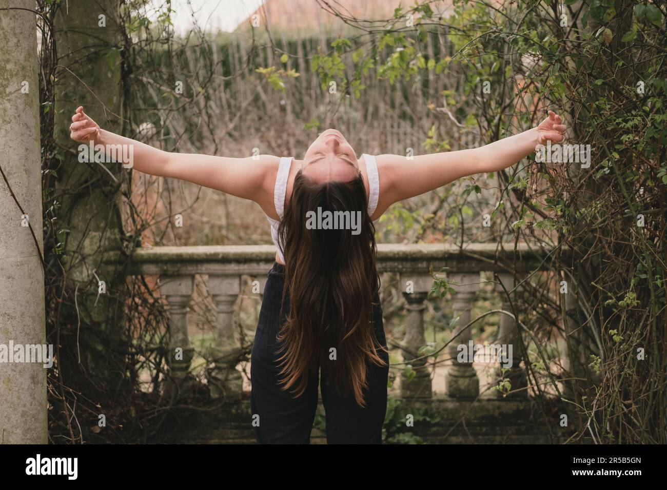 Woman yogi doing a modified standing back bend with eyes closed in a ... Woman yogi doing a modified standing back bend with eyes closed in a ...