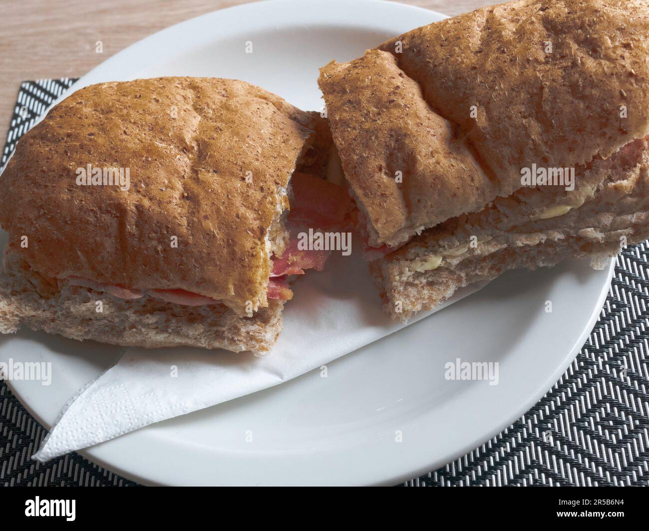 Soft brown roll filled with grilled bacon morning snack in a café in ...