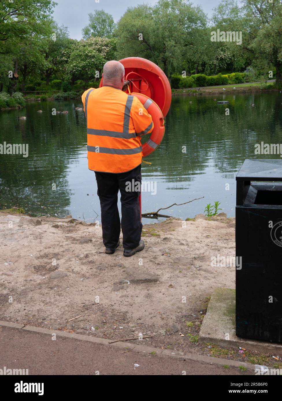 Park keeper replacing life belt in its carrier by the Locke Park lake ...
