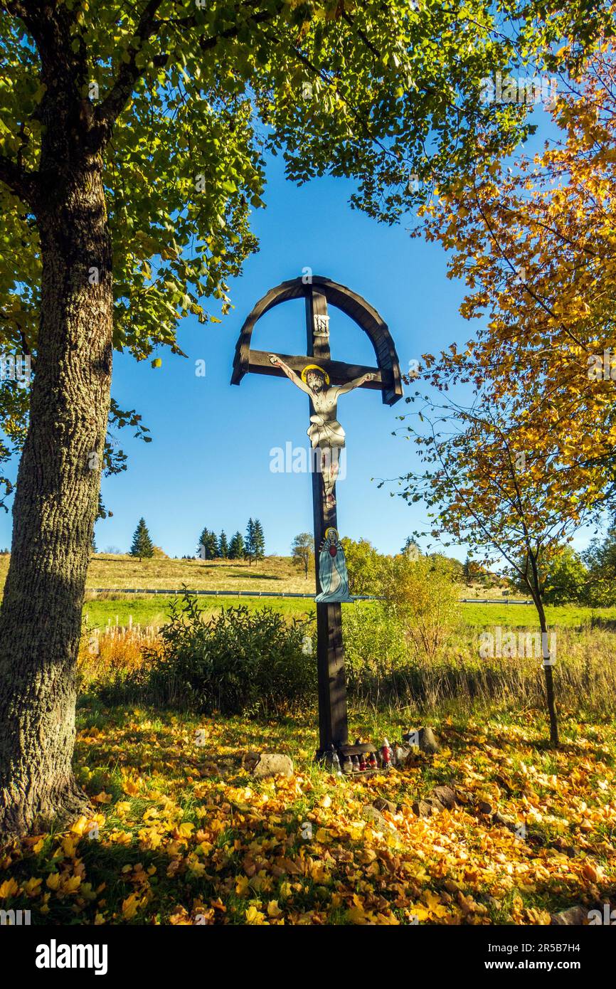 A wooden cross surrounded by lush trees. Church of Saint John the ...