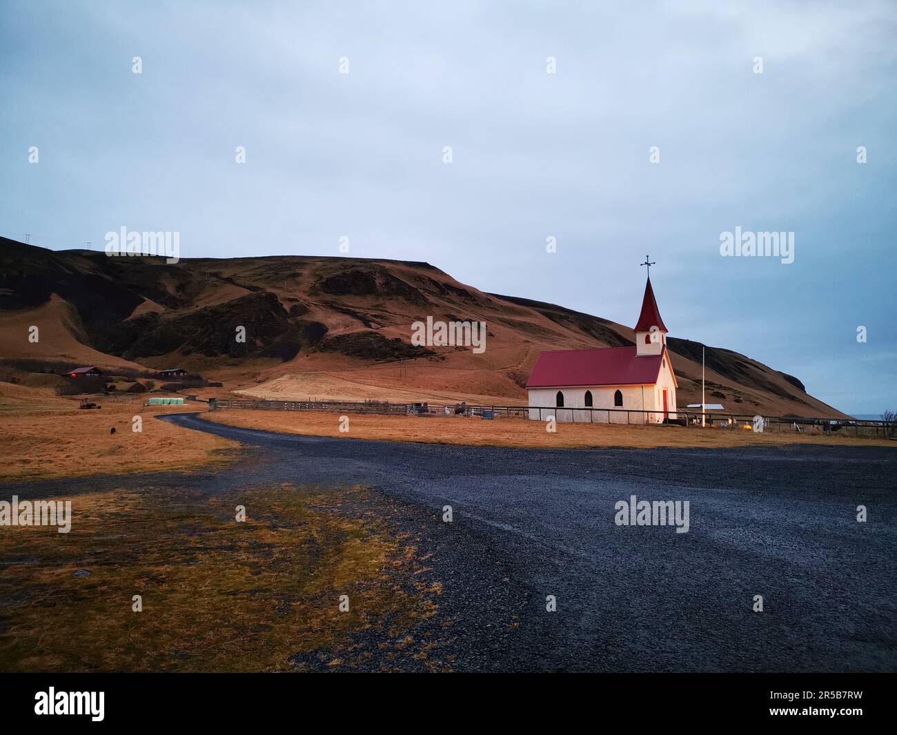 A scenic two-lane road stretches out to the horizon, flanked by a ...