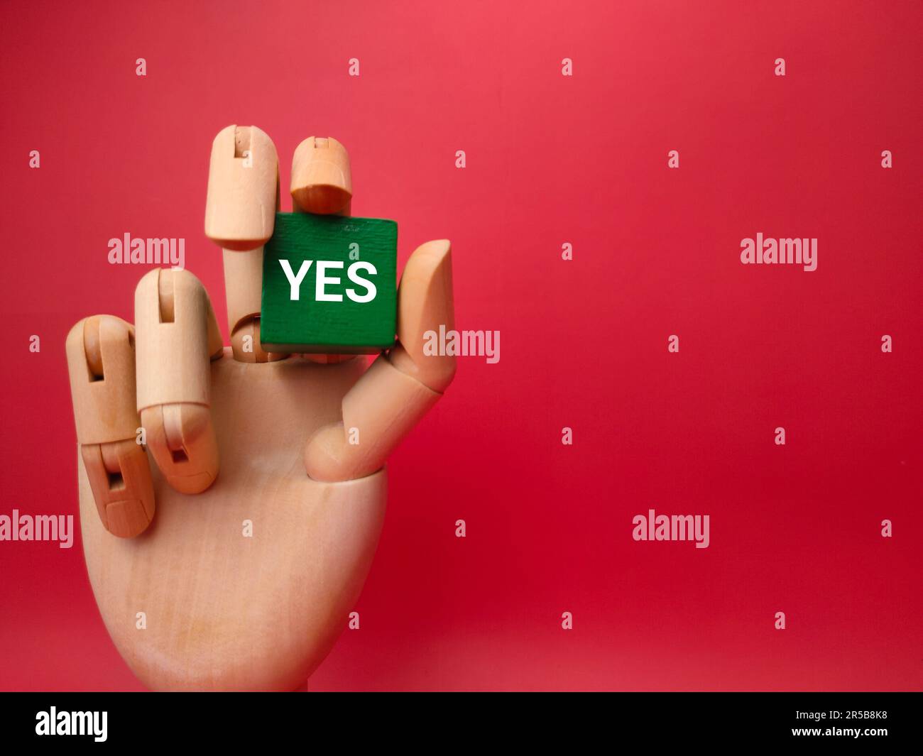 A miniature wooden block with the word 'Yes' inscribed in bold black ...