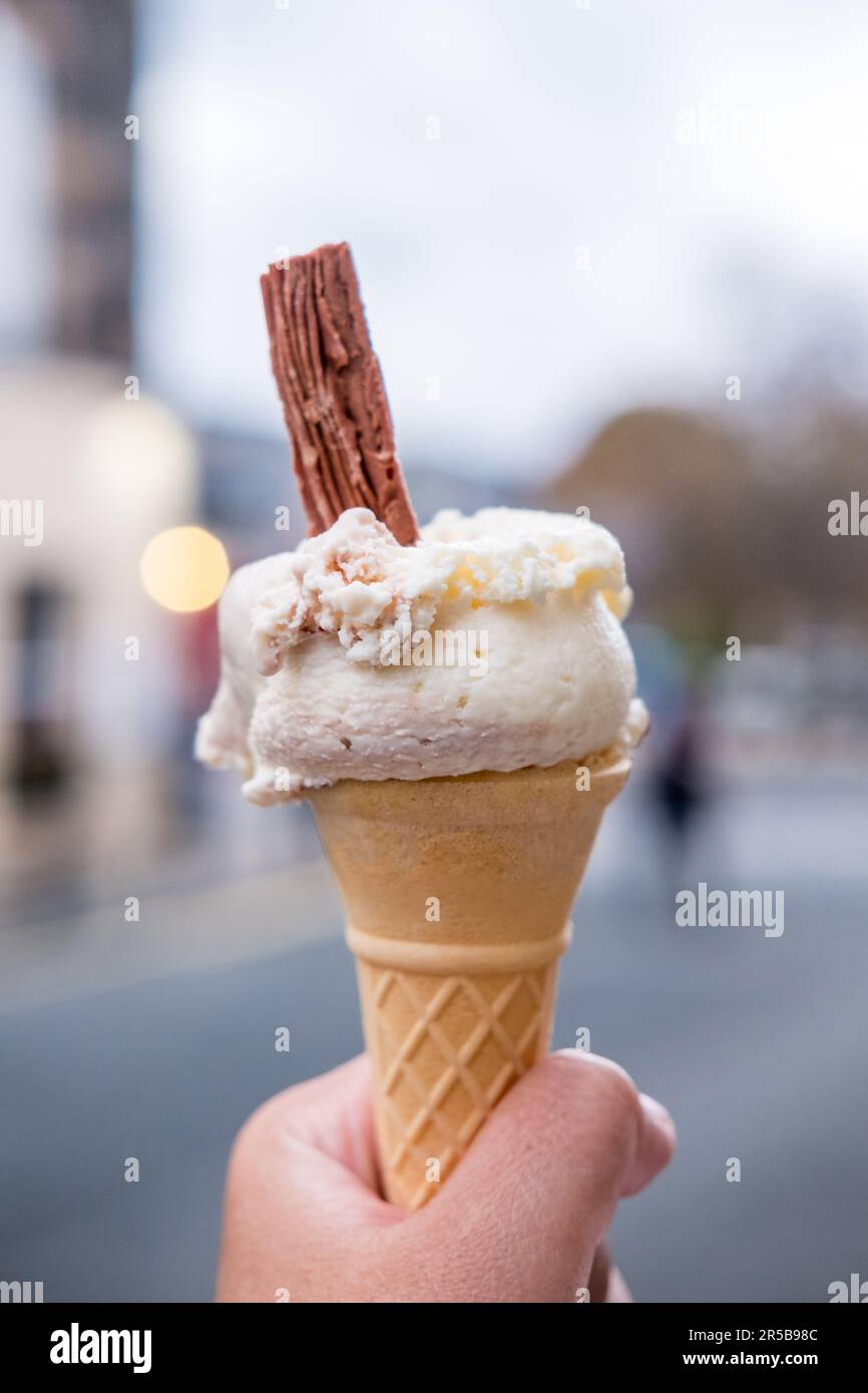 Hand holding Ice Cream Cone with Chocolate Flakes, with blur background ...