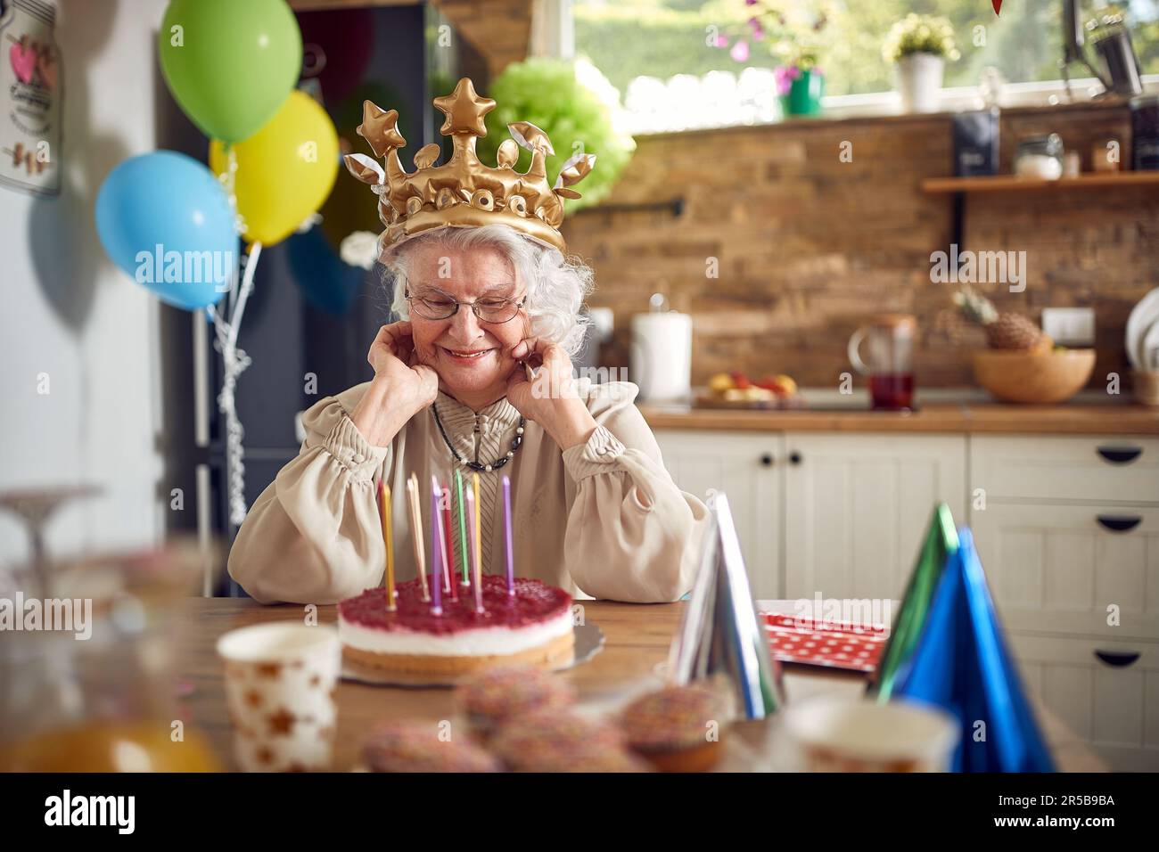 Beloved grandma takes a seat at the beautifully adorned table, wearing ...