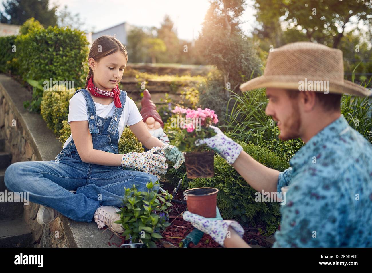 Father and his daughter work hand in hand. The father carefully lifts a ...