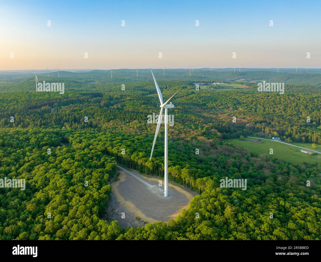 Afternoon aerial drone view of wind power turbines under construction ...