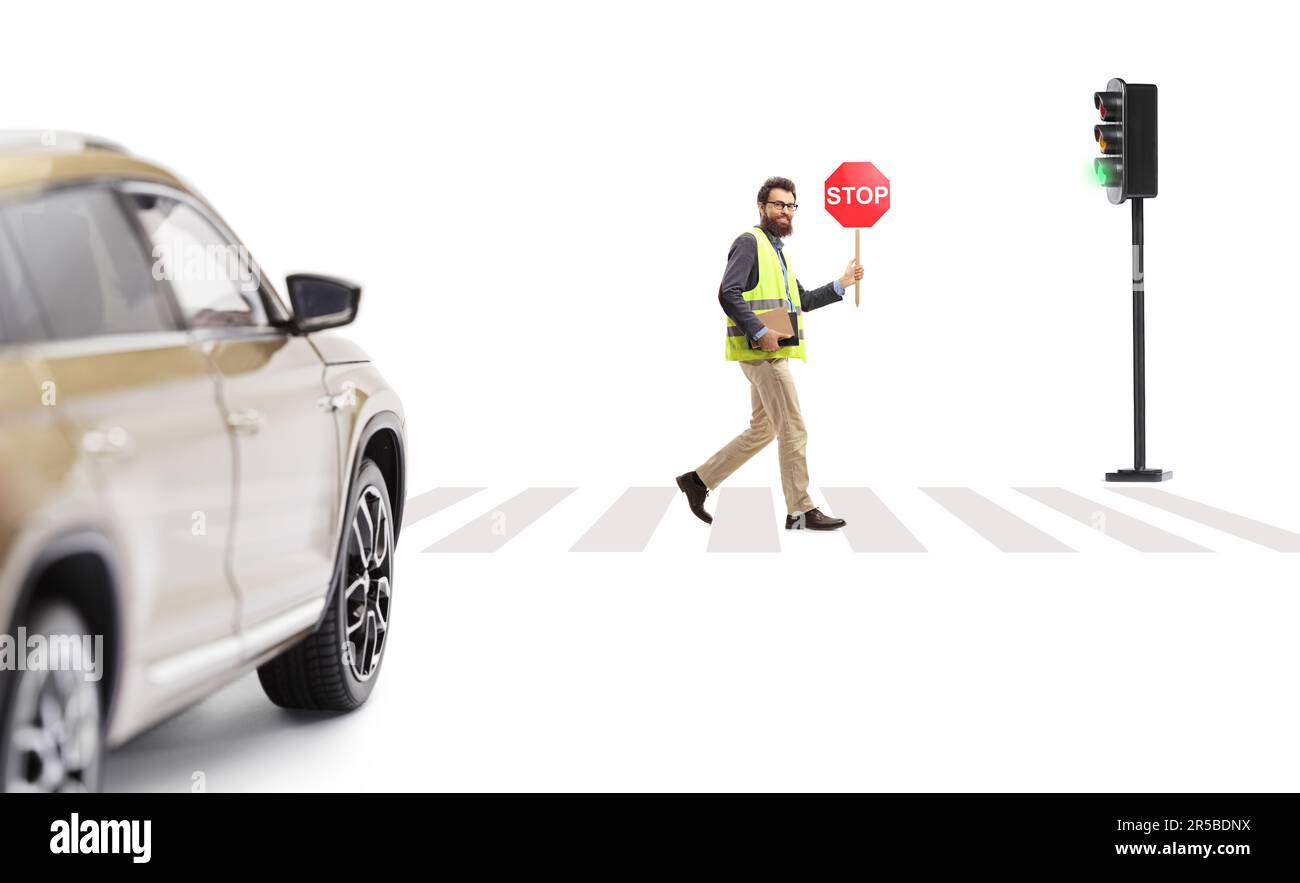 Bearded man in a safety vest walking with a stop traffic sign at a ...