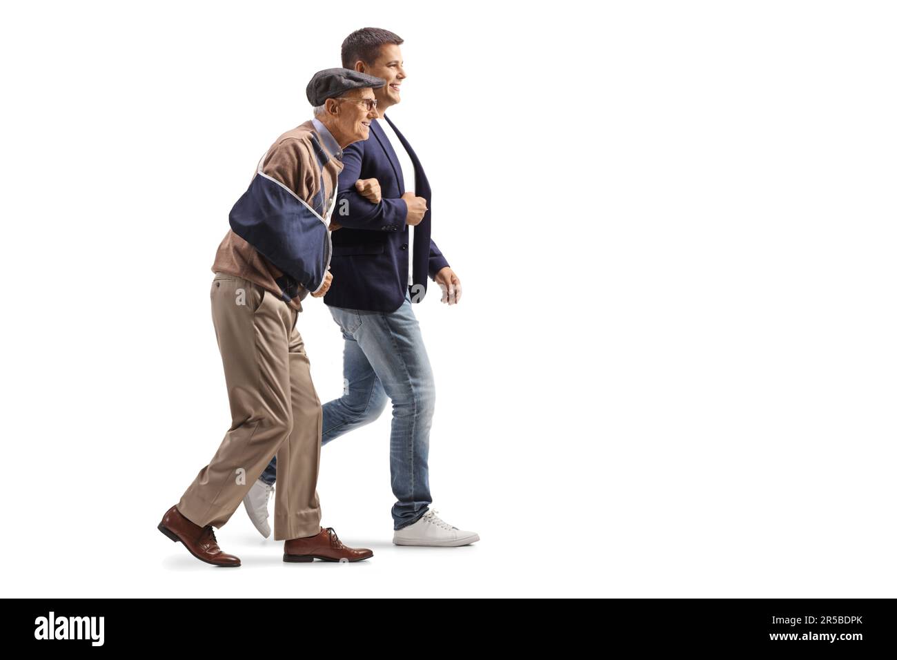Young man walking with a senior man with an injured arm in a sling ...
