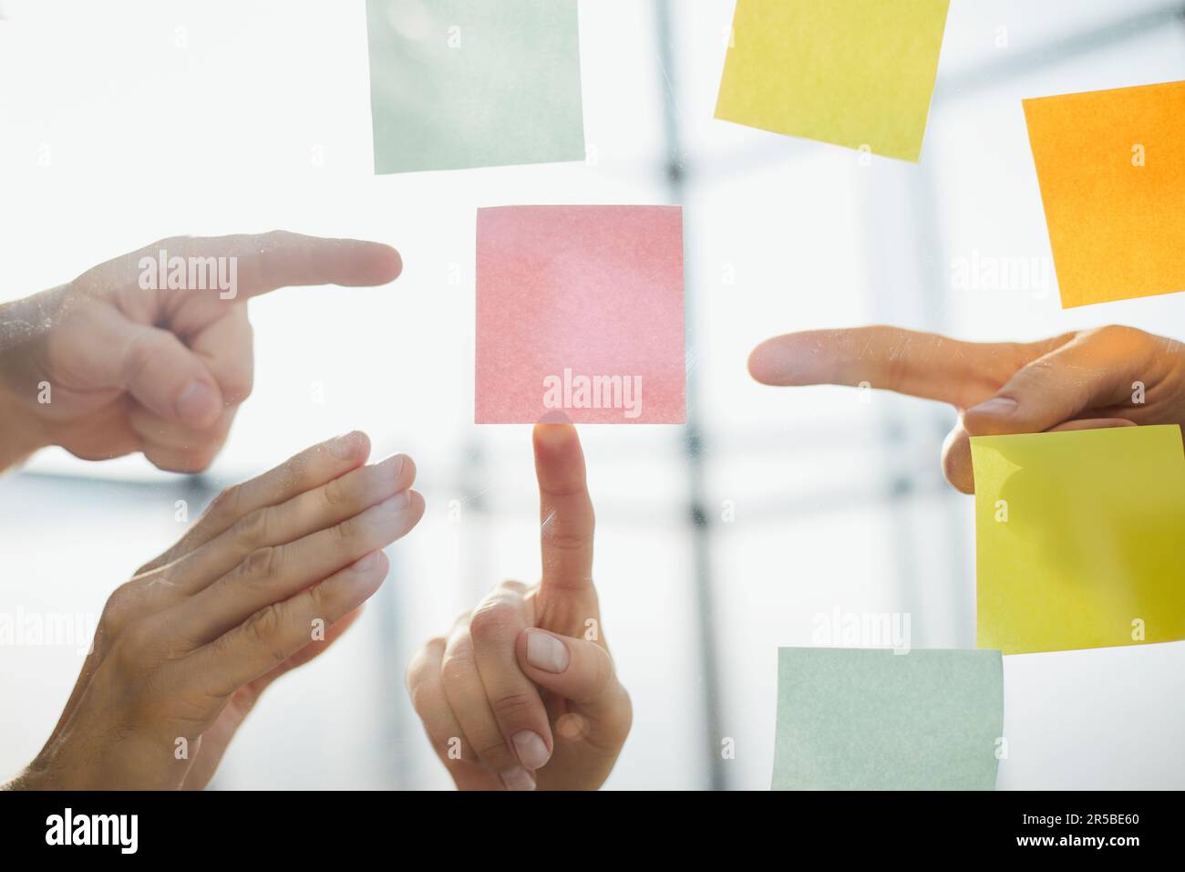 Hand pointing at pink paper or post against office background Stock ...