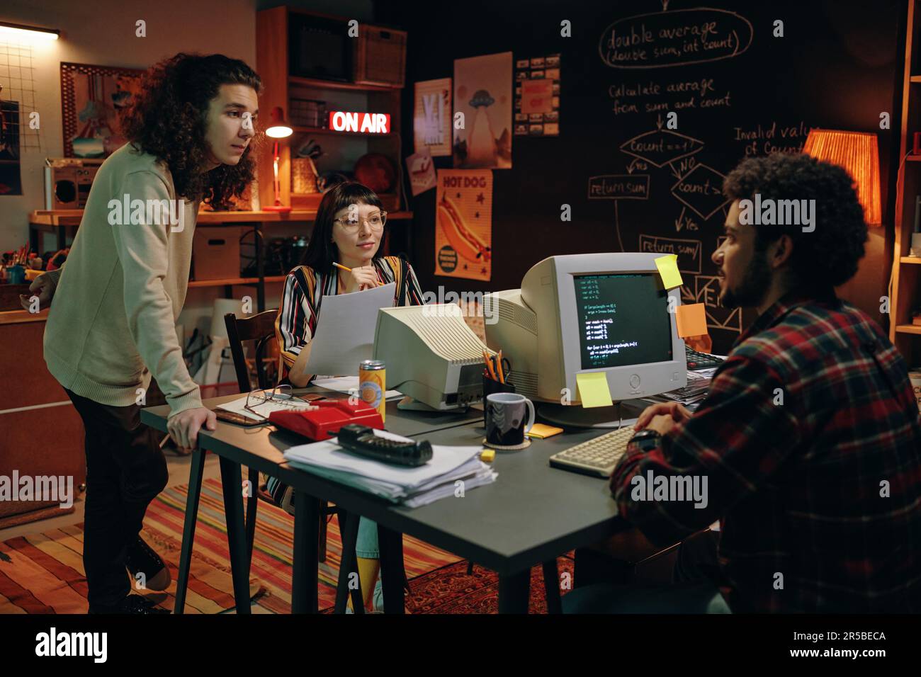 Group of young people working over new project at table with computers ...