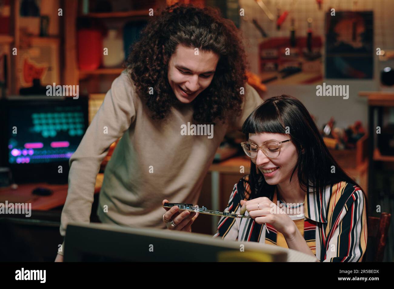 Young smiling people working with computer chip and developing new ...