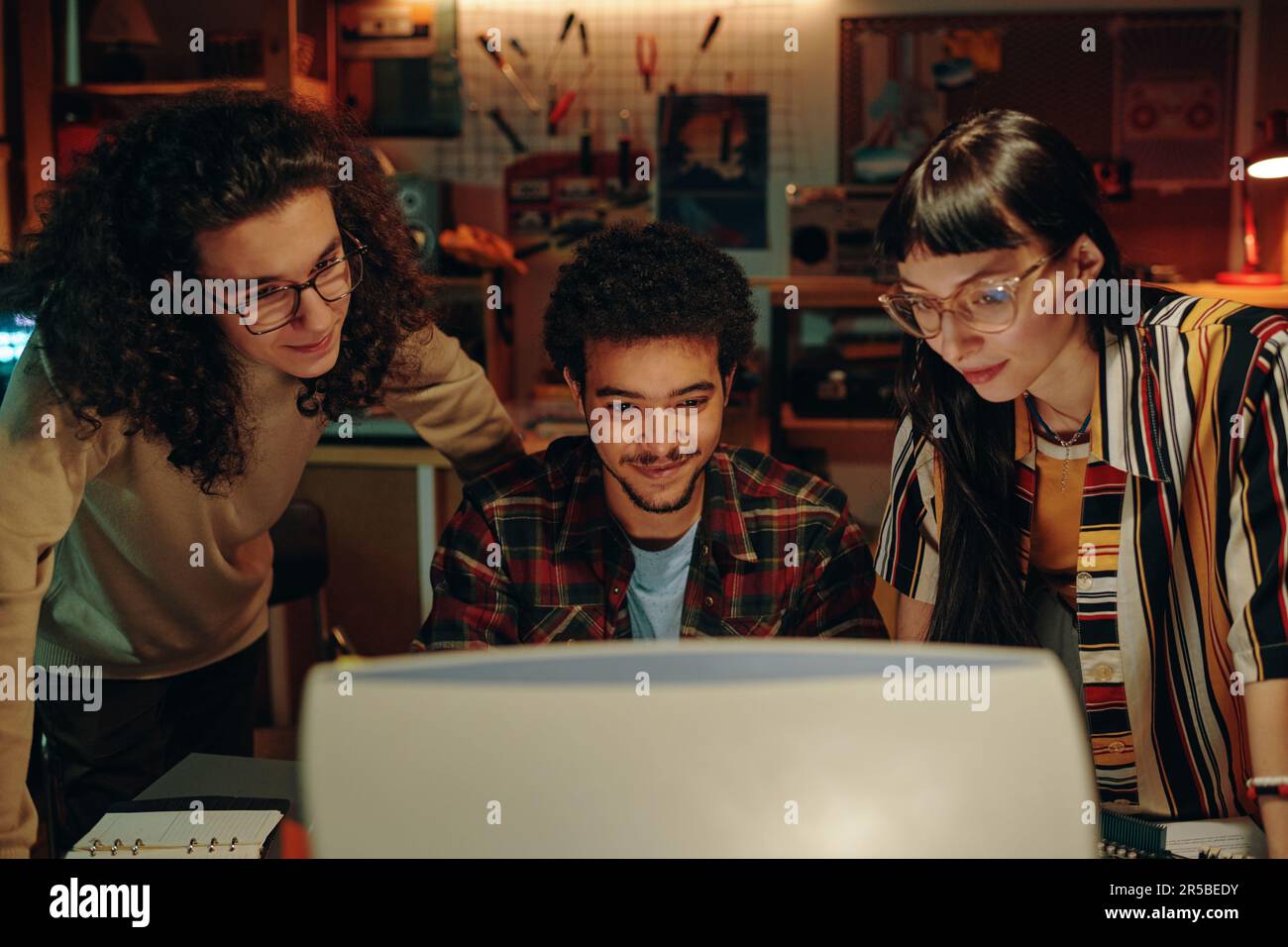 Group of young people developing new computer program, they watching ...