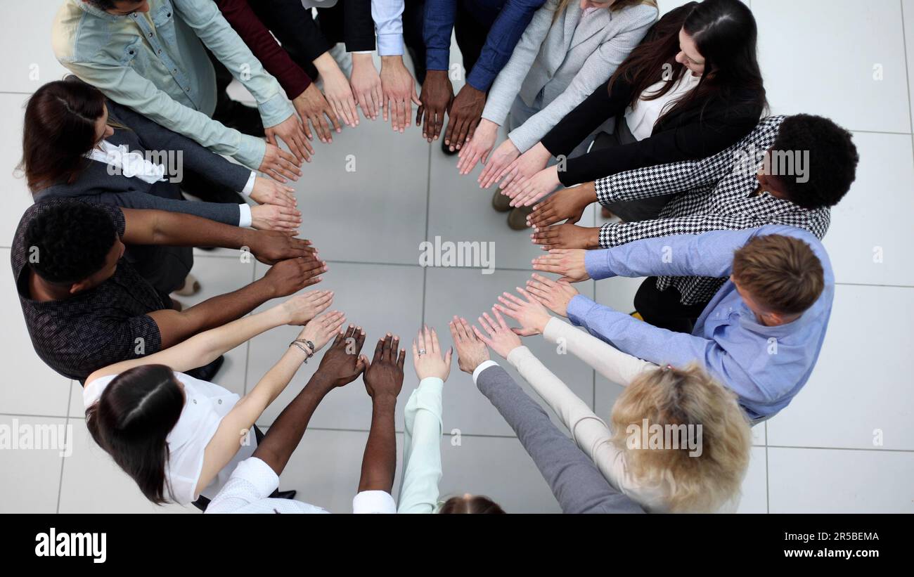 Friends with stack of hands showing unity and teamwork Stock Photo - Alamy