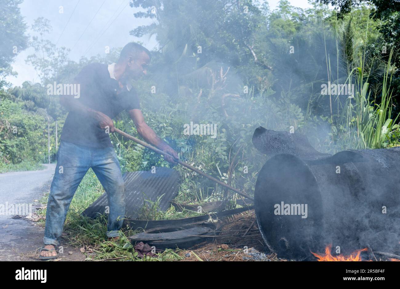 The construction workers near a smoke emitting industrial barrel in a ...