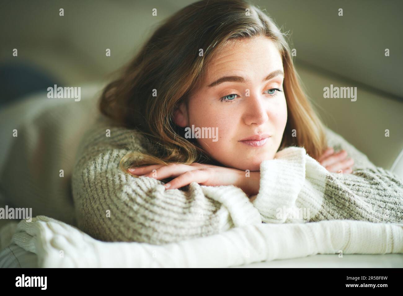 Young girl lying on couch, looking nowhere, sad emotions Stock Photo - Alamy