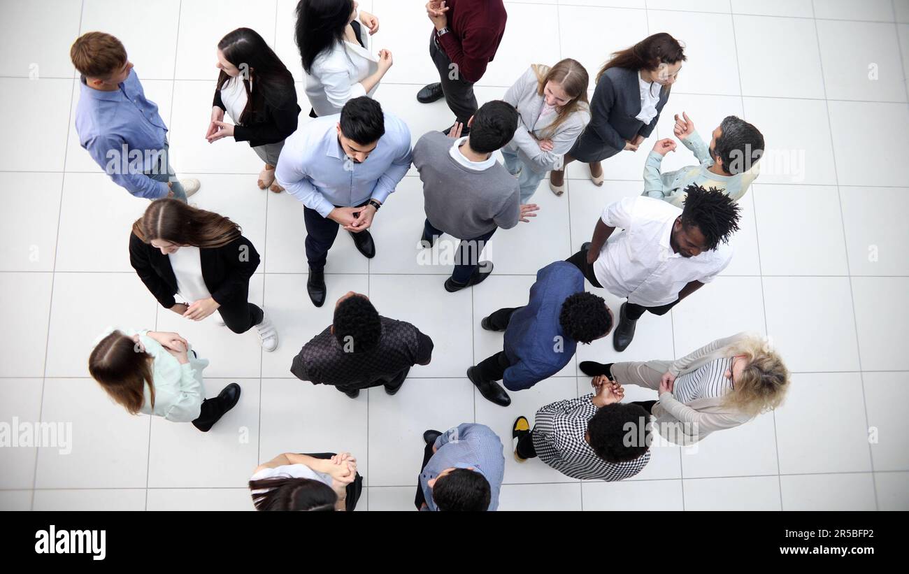 office workers and foreign employees stand and talk in the office lobby ...