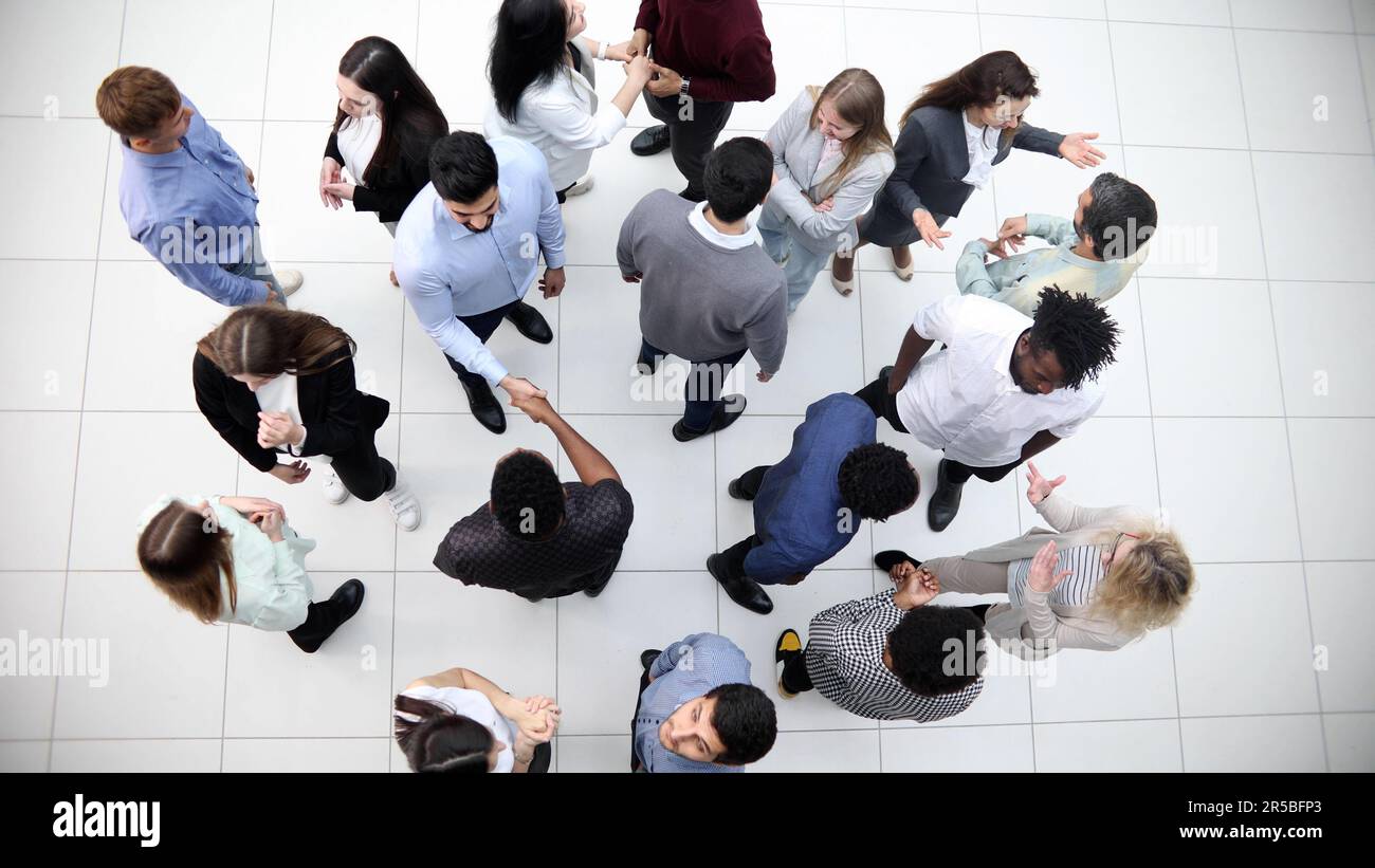 multinational office workers and foreign employees stand and talk in ...