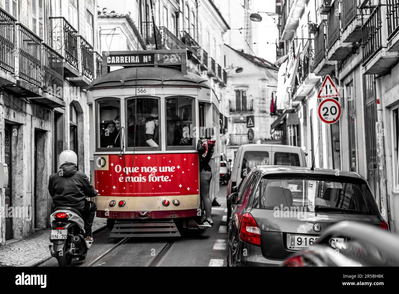 A modern city street scene featuring a streetcar on the tracks running ...