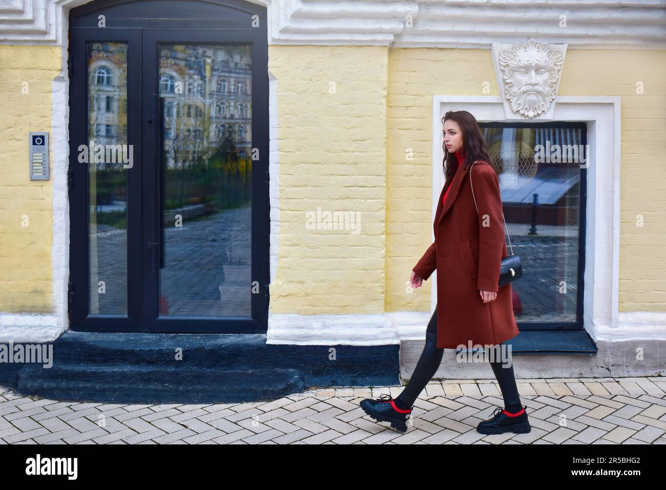 Woman with a concerned look on her face walks in a hurry down the ...