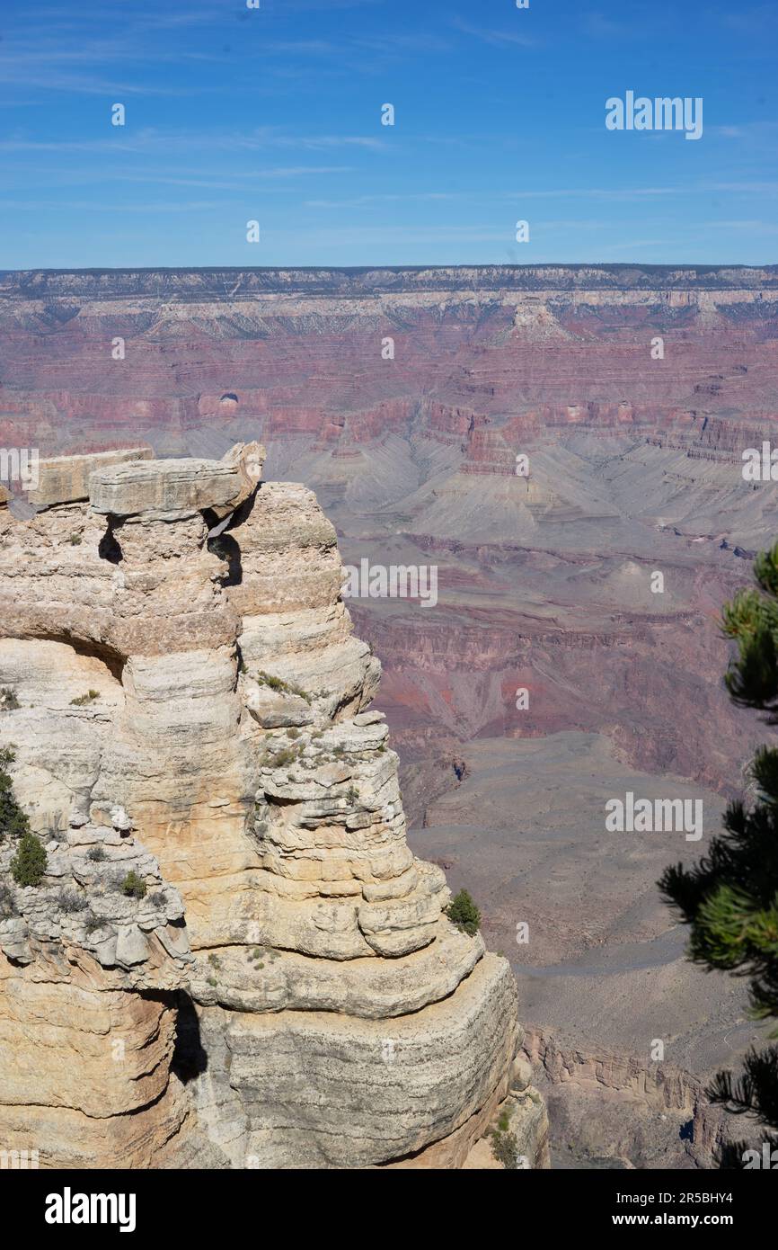 A majestic rocky cliff provides a stunning view of the canyon below ...