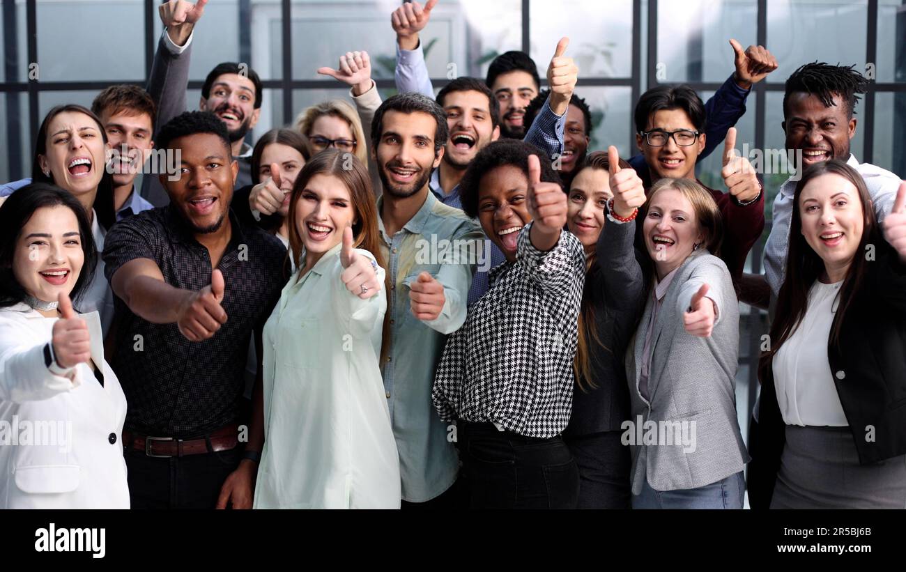 Large Group of people standing together in studio showing thumbs up ...