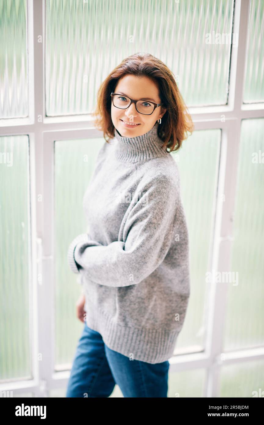 Interior portrait of beautiful 40 year old woman relaxing next to ...