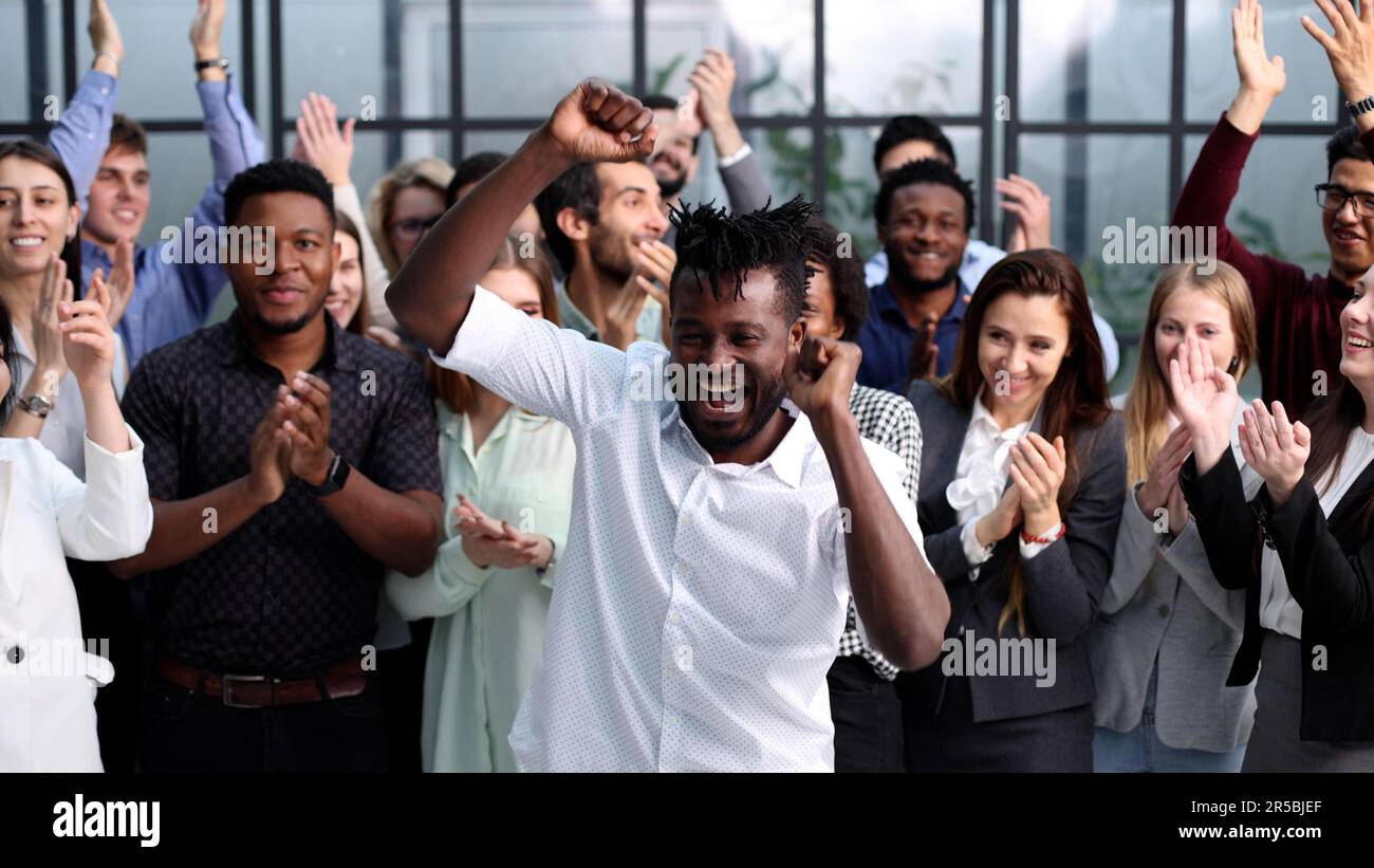 Impressed young coworkers clapping and looking at camera Stock Photo ...
