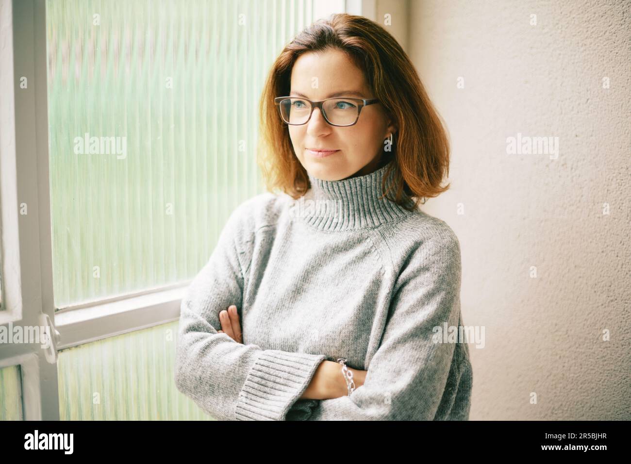 Interior portrait of beautiful 40 year old woman relaxing next to ...