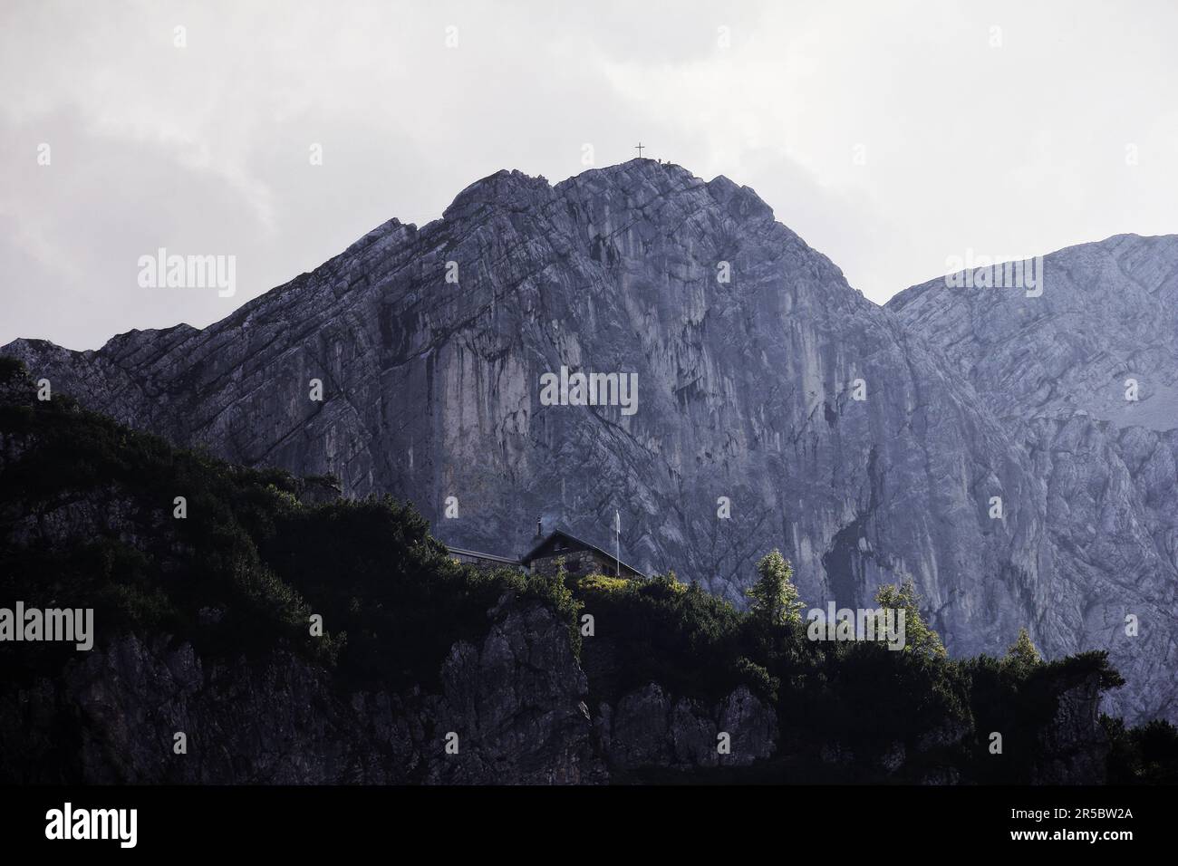 A scenic view of a tall mountain peak with dense vegetation at its base ...