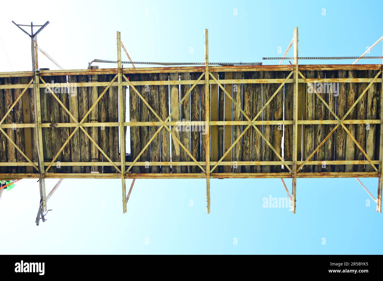 Steel and wooden bridge for pedestrians with blue sky in the background ...