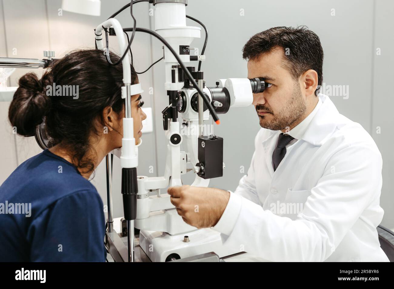 An ophthalmologist is performing a medical examination on a female ...