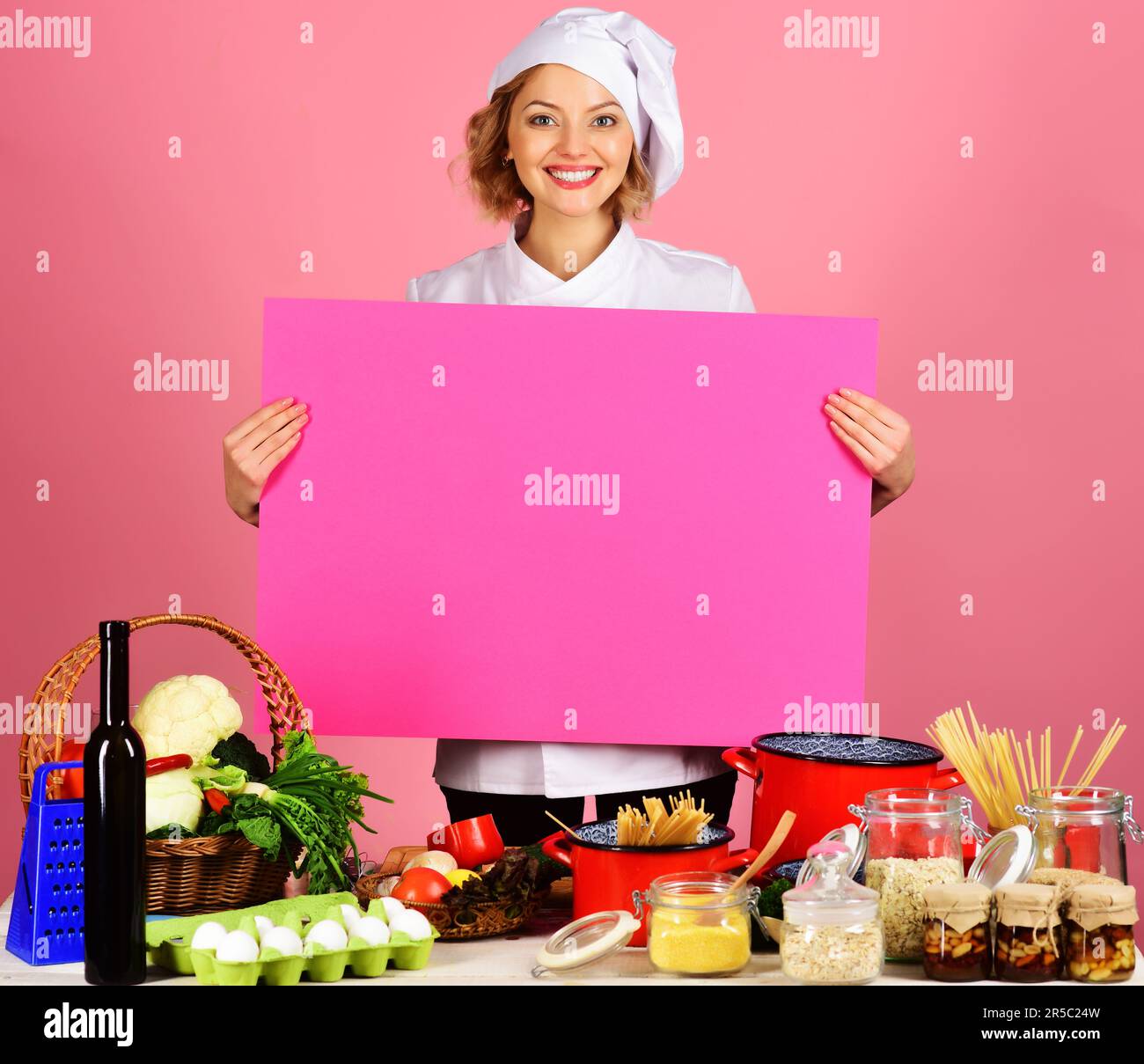 Female chef cook with blank board for advertise menu. Food preparation ...