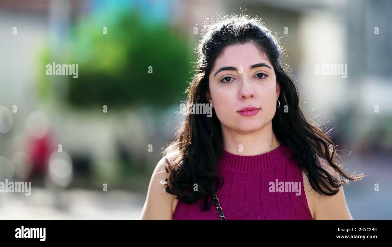 Portrait of a young woman turning head with stoic surprise toward ...