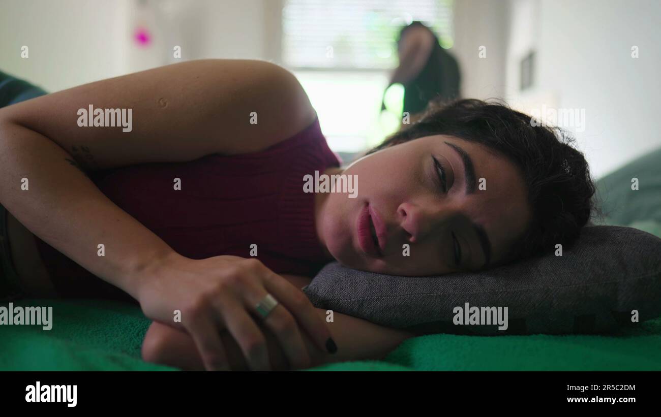 Relationship in crisis Dismissive woman lying in bed rolling eyes while ...