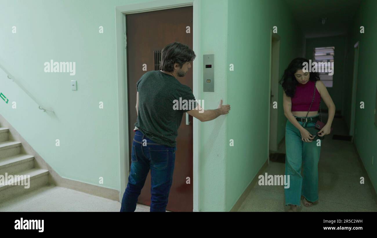 Couple leaving apartment standing by elevator building. Lifestyle scene ...