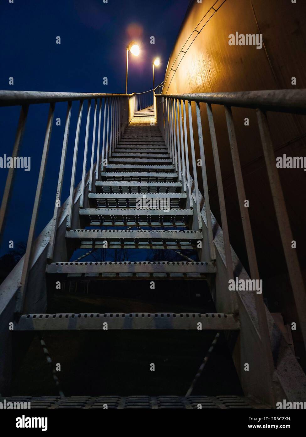 An image of a staircase illuminated in the evening, with a dark night ...