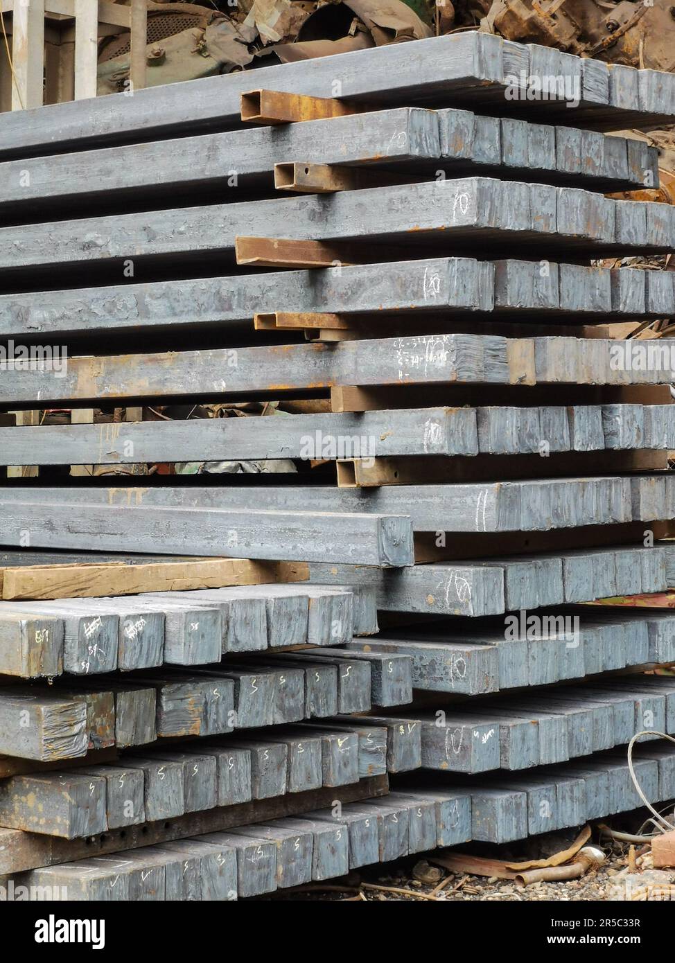 A vertical shot of a stack of steel billets in a steel plant warehouse ...