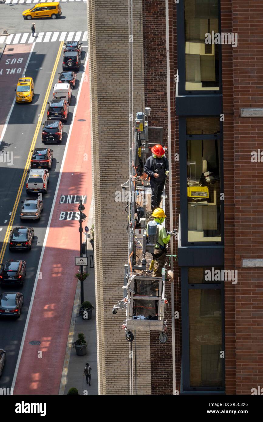 Construction workers high above 34th Street in New York City in a ...