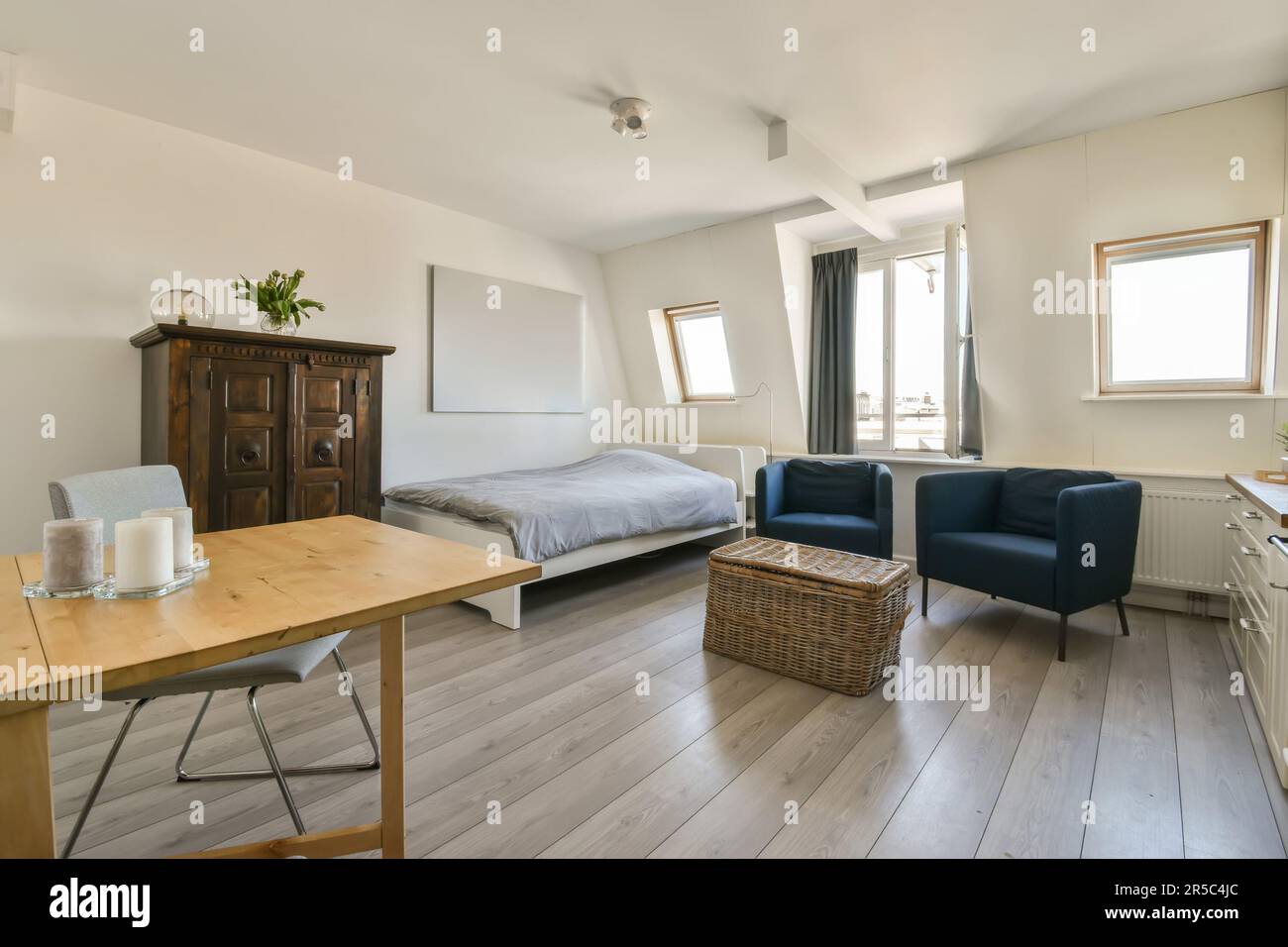 a room with a bed, chair and desk in the middle of the room there is a ...