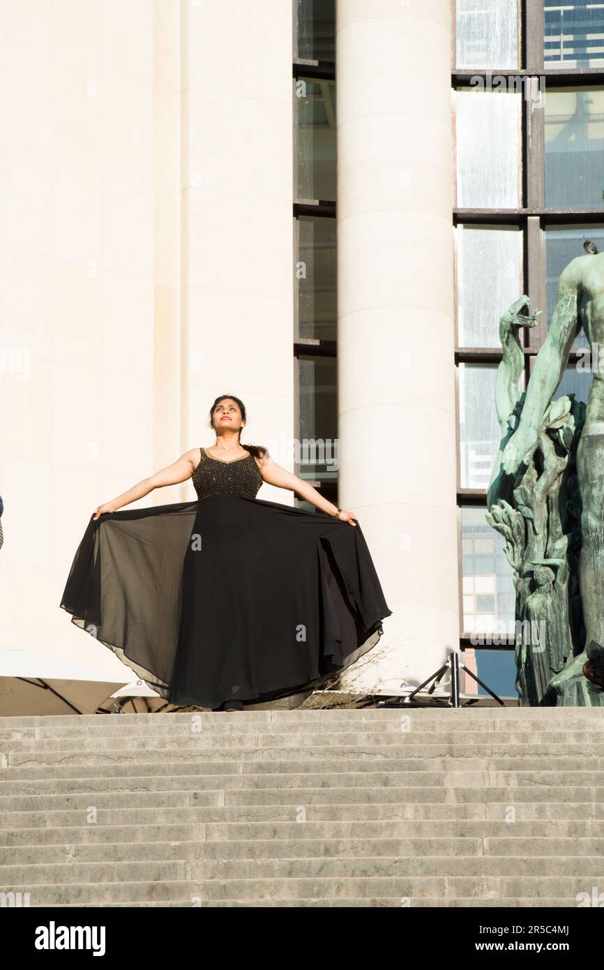 A beautiful woman dancer in a long black dress dancing in Paris, France ...