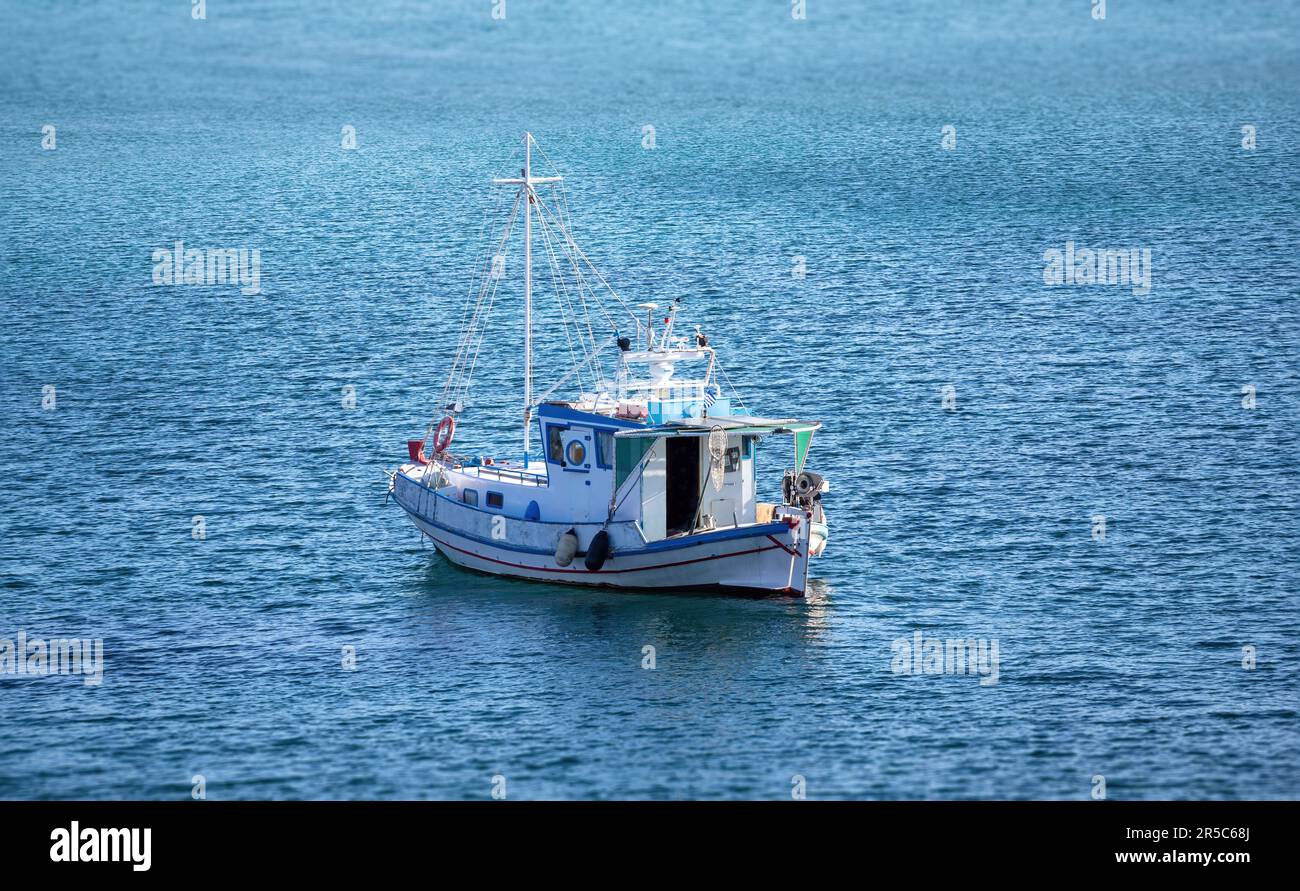 Traditional fishing boat, trawler moored, rippled sea water background ...
