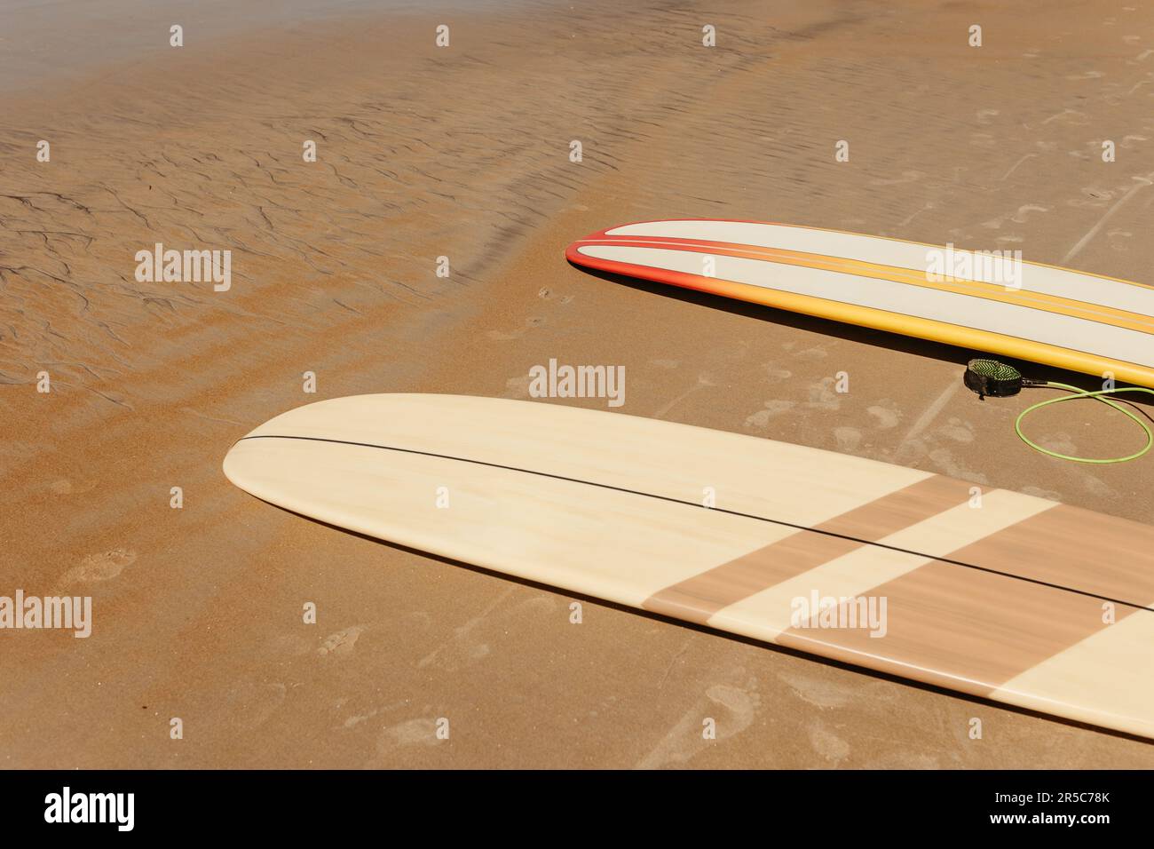 An idyllic beach scene featuring two colorful surfboards lying side by ...