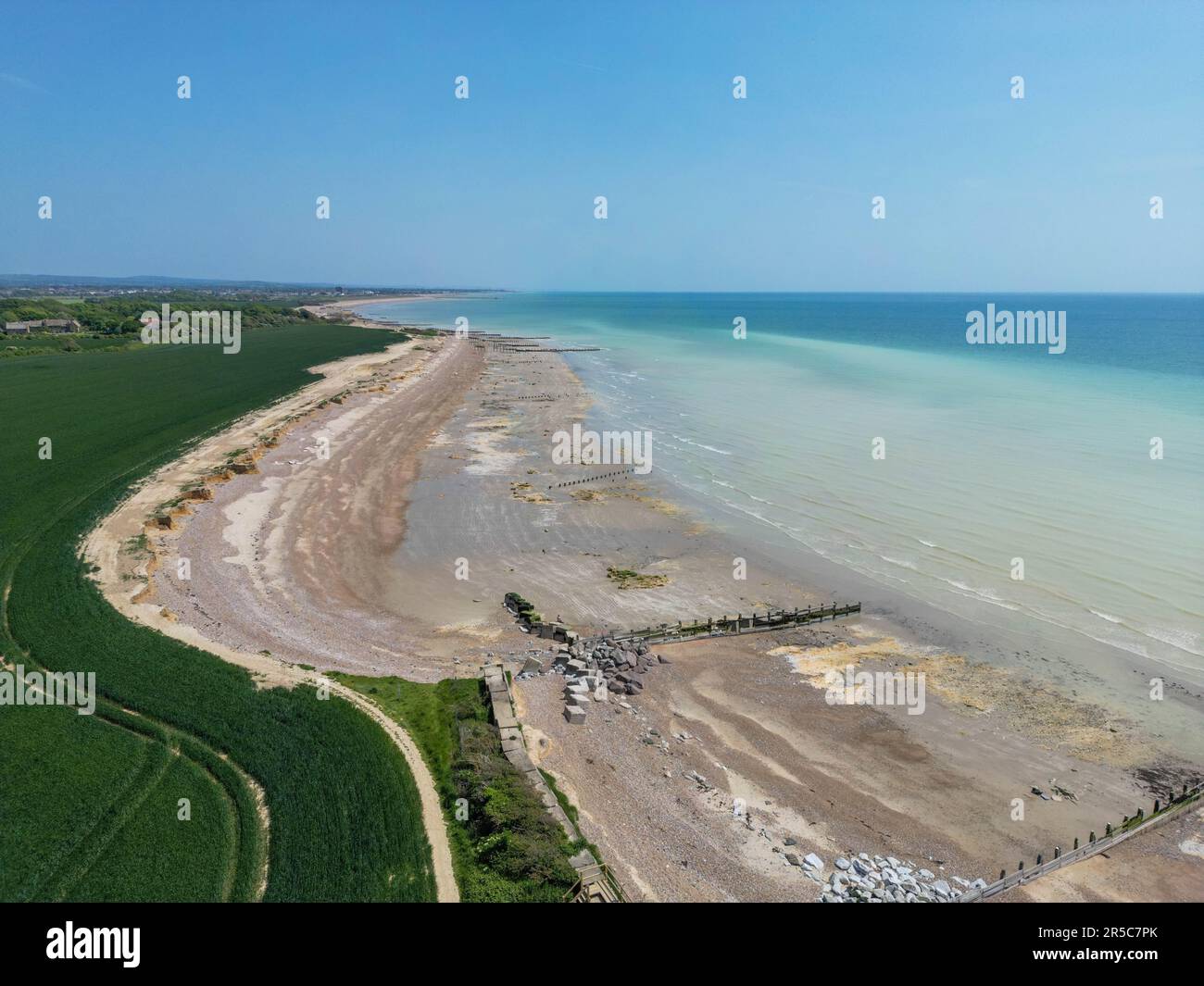An Aerial photo of a lush green grassy field with a beach shoreline in ...